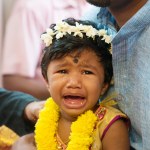 Baby girl crying in ear piercing ceremony Stock Photo by ©szefei 97296602