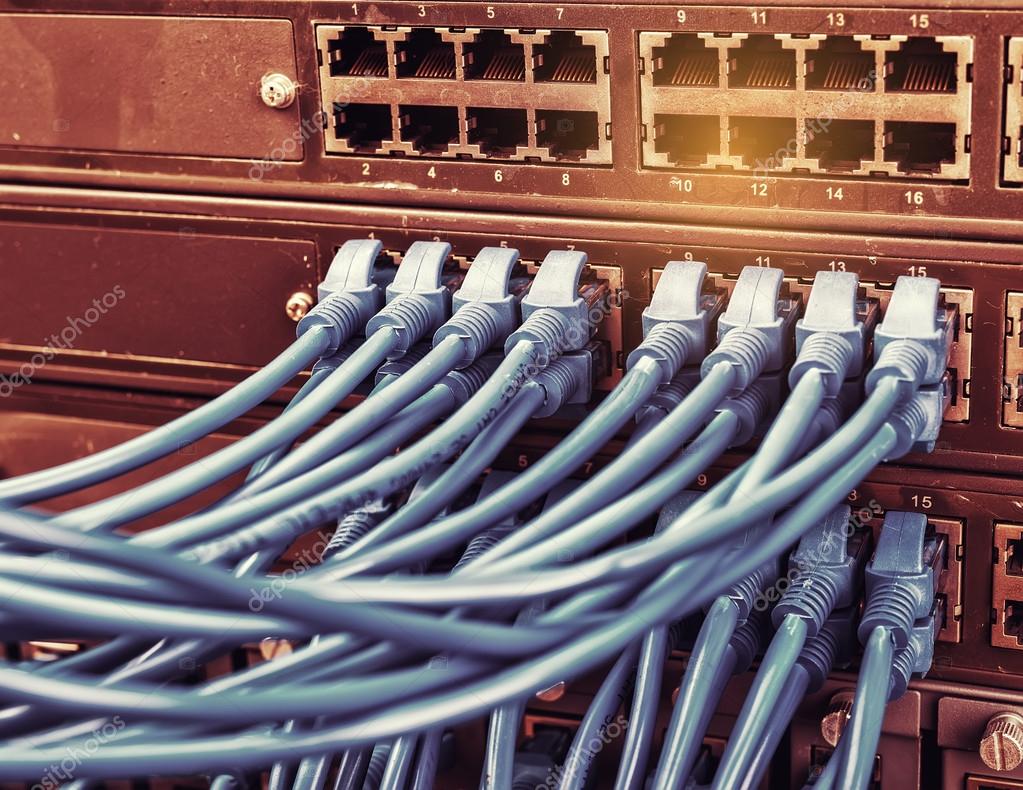 Network cables and hub closeup with fiber optical background — Stock ...