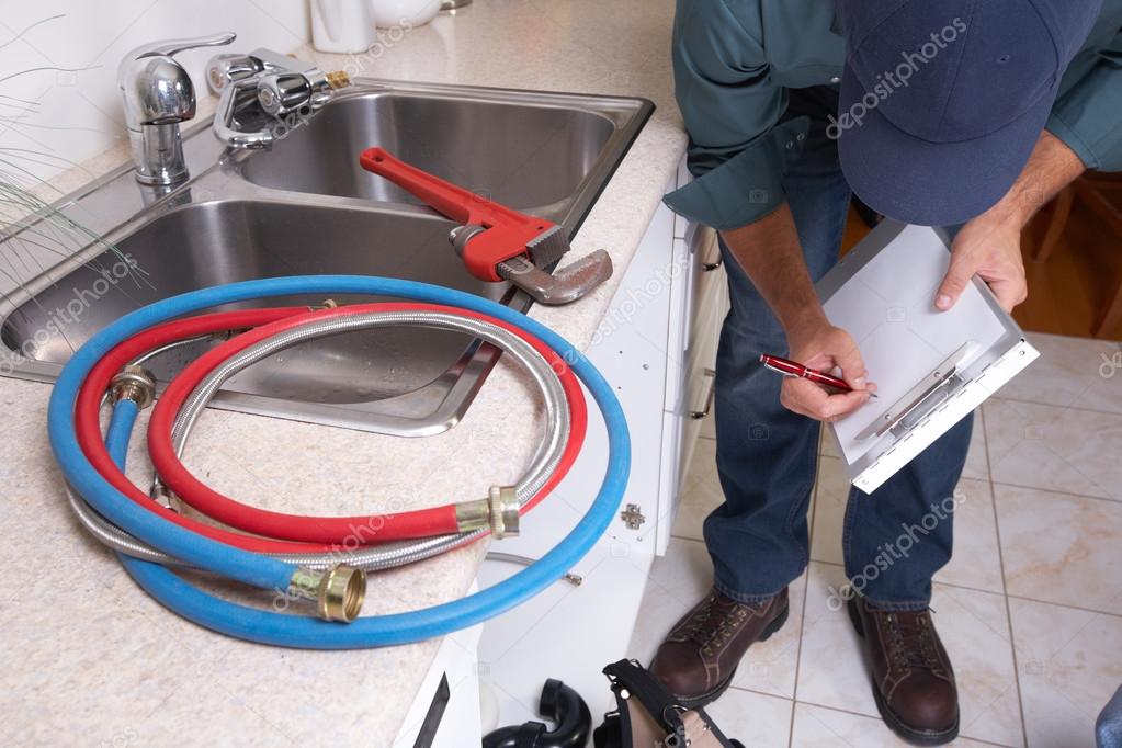 Plumber on the kitchen. — Stock Photo © petrkurgan #60569909