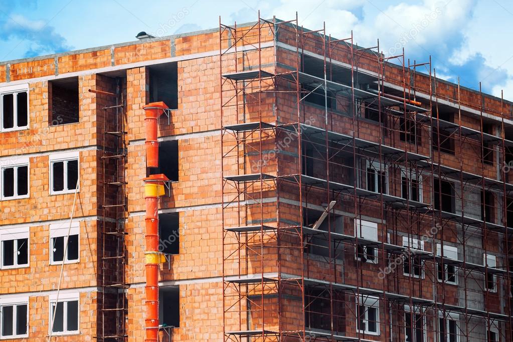 Scaffolding around new unrendered building at construction site Stock ...