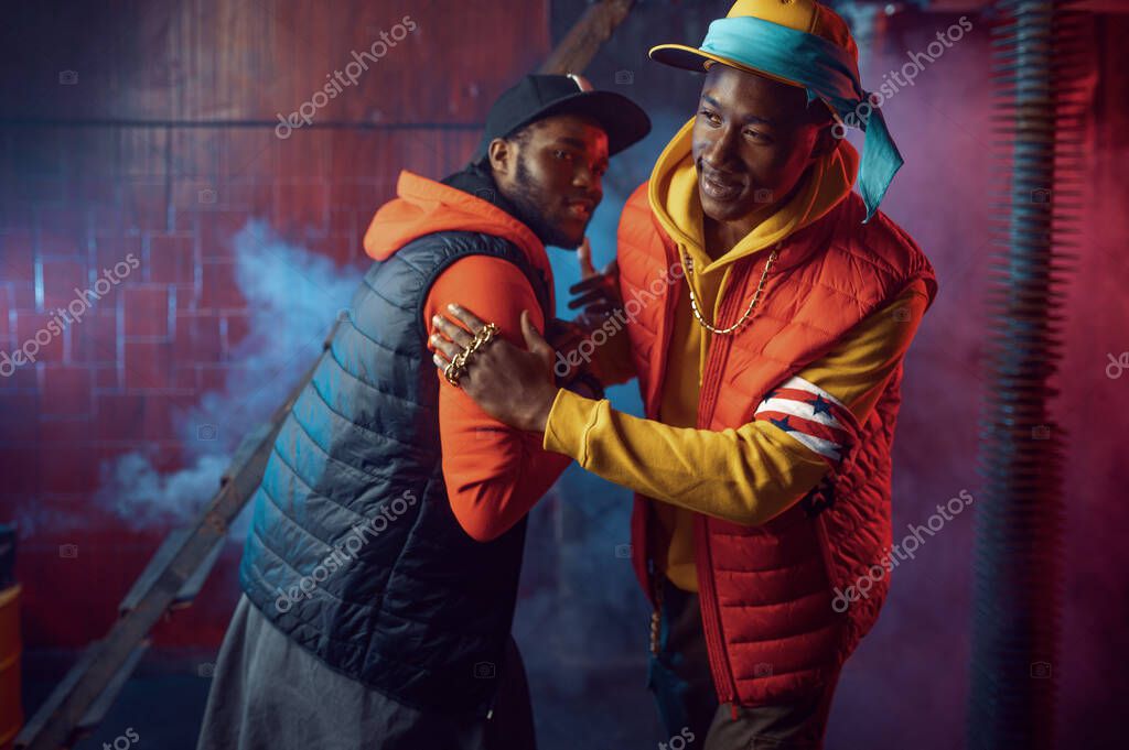 Dos elegantes raperos con joyas de oro en estudio fresco, decoración ...