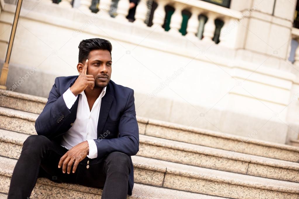 Pensive indian man sitting on steps Stock Photo by ©michaelpuche 119476498