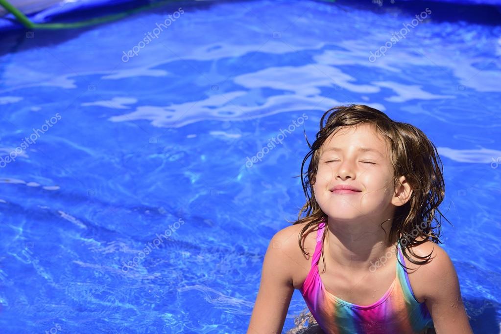 Child relaxing in pool sunbathing Stock Photo by ©mangostock 53980235
