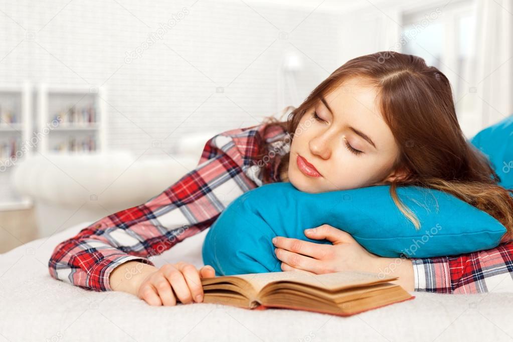 Young girl slepping with a book in bed — Stock Photo © gdolgikh #65151231