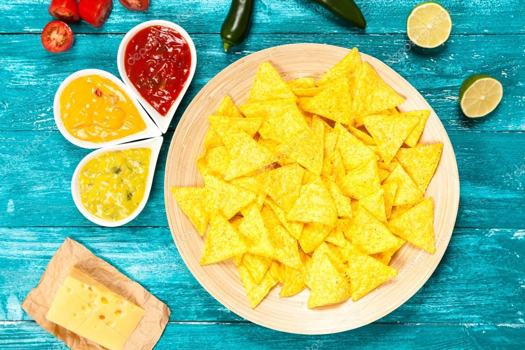 Plate of nachos with different dips Stock Photo by ©gdolgikh 80532622