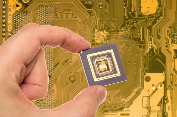Microprocessor in hand over PCB — Stock Photo © pgkirich #104745090