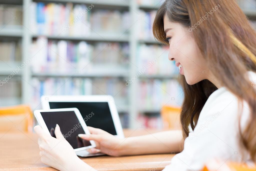 Girl with laptop and tablet in school library Stock Photo by ©zhudifeng ...