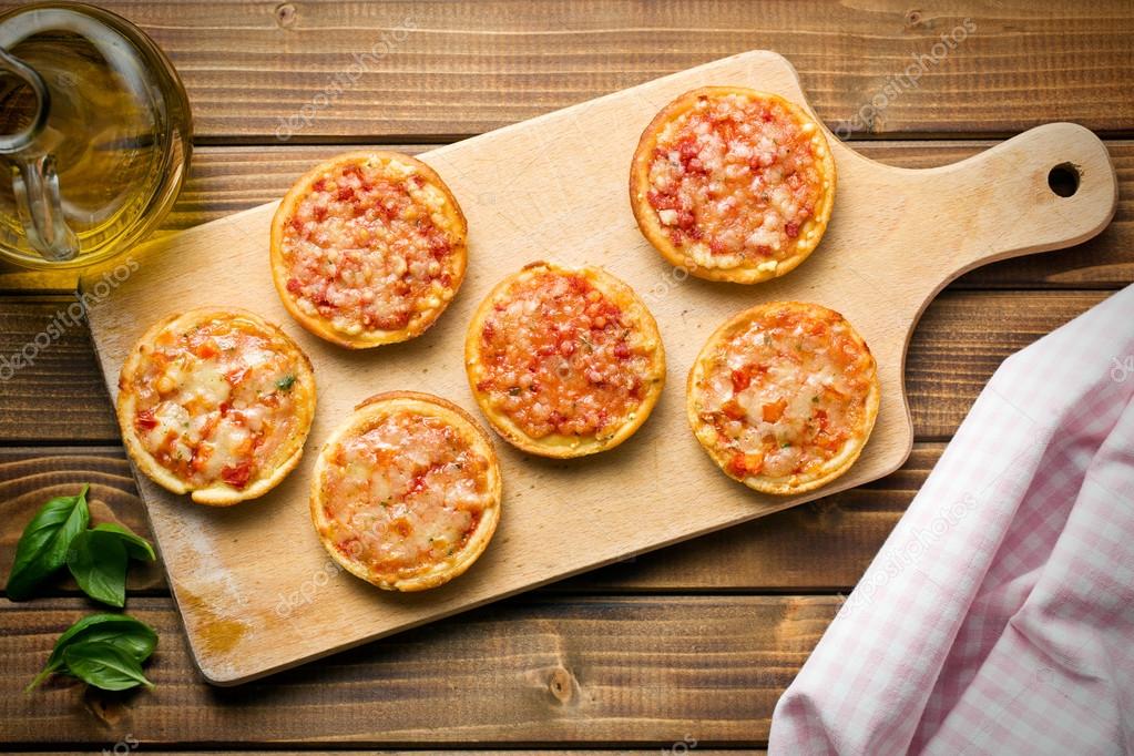 Mini pizza on cutting board — Stock Photo © jirkaejc #64681235