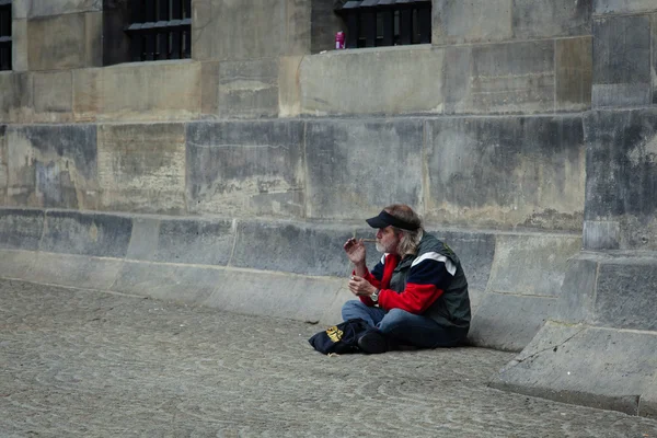 Amsterdam, The Netherlands - May 9, 2015: old poor man sitting and ...