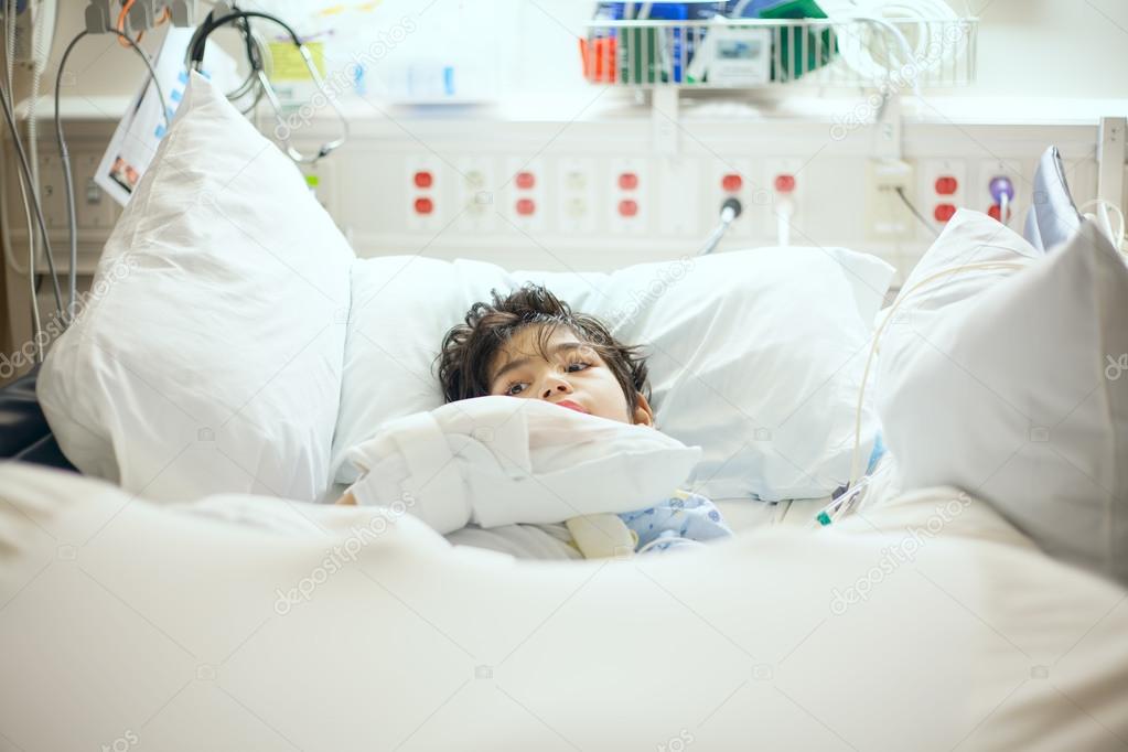 Disabled little boy lying sick in hospital bed Stock Photo by ...