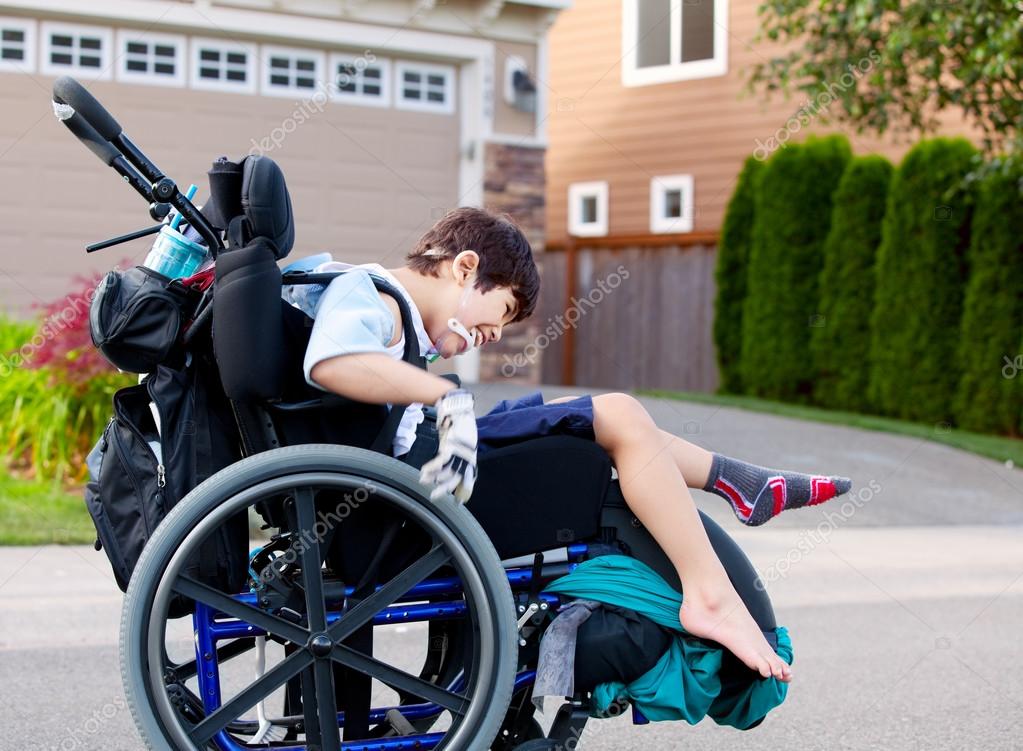Happy little disabled boy outdoors in wheelchair Stock Photo by ...