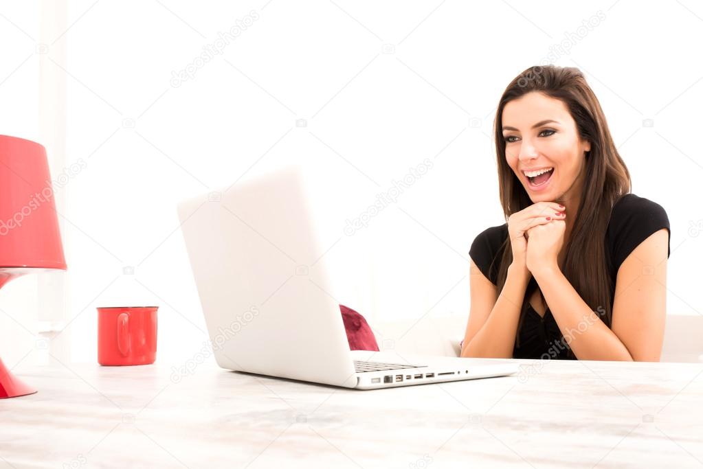 Young beautiful woman happily using a Laptop at home Stock Photo by ...