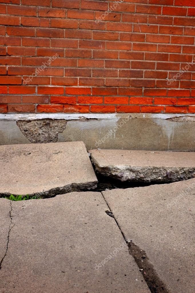 Antigua pared de ladrillo de acera agrietada de cemento roto 2022