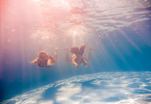 Underwater couple in the swimming pool. — Stock Photo © netfalls #117394980