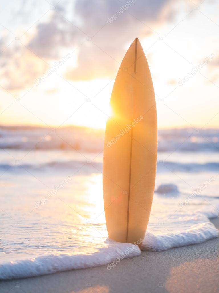 Surfboard In Sand And Sunset