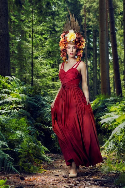 Woman in a long red dress alone in the forest. Fabulous and mysterious ...