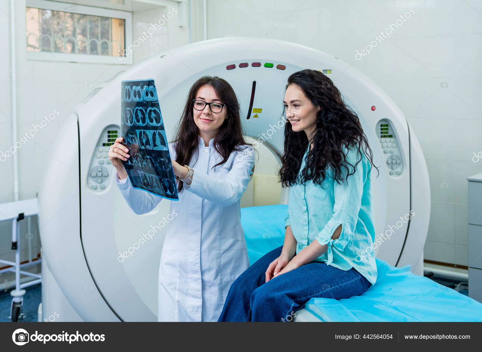 Radiólogo con una paciente femenina examinando una tomografía ...