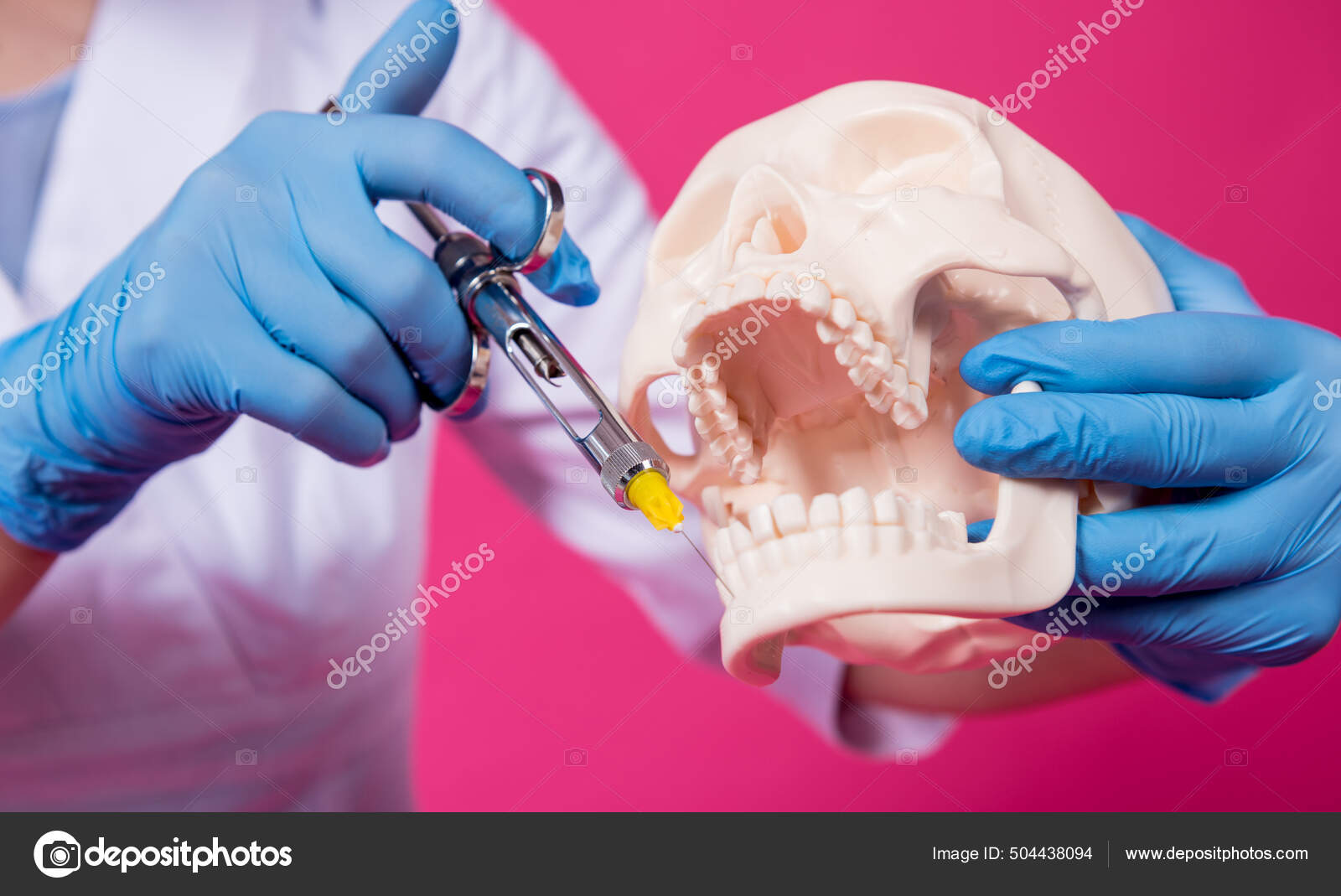 Woman dentist with a carpool syringe injects anesthetic into the gum of ...
