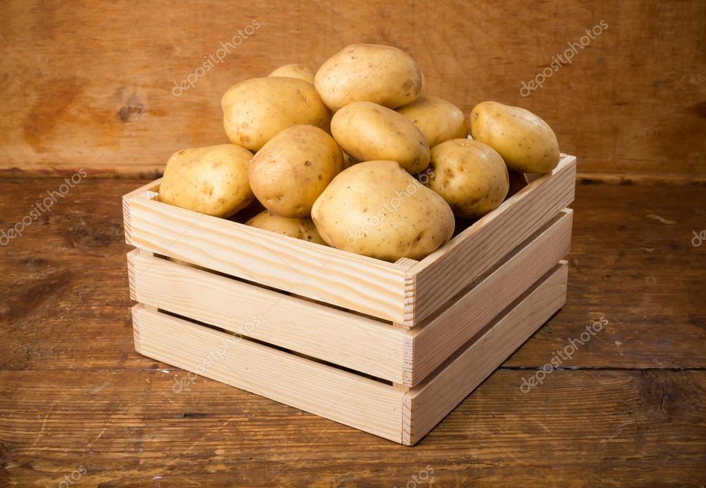Potatoes in box on background Stock Photo by ©korovin 86581278