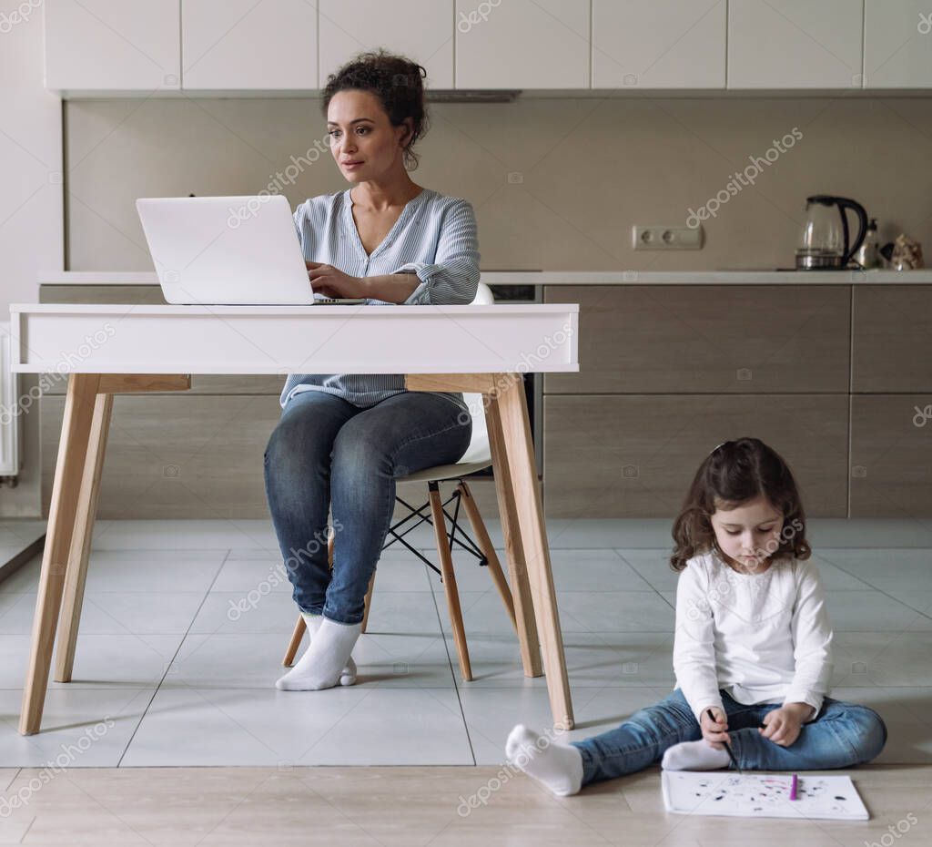 Mamá trabaja en casa con la computadora y los documentos sentados a la ...