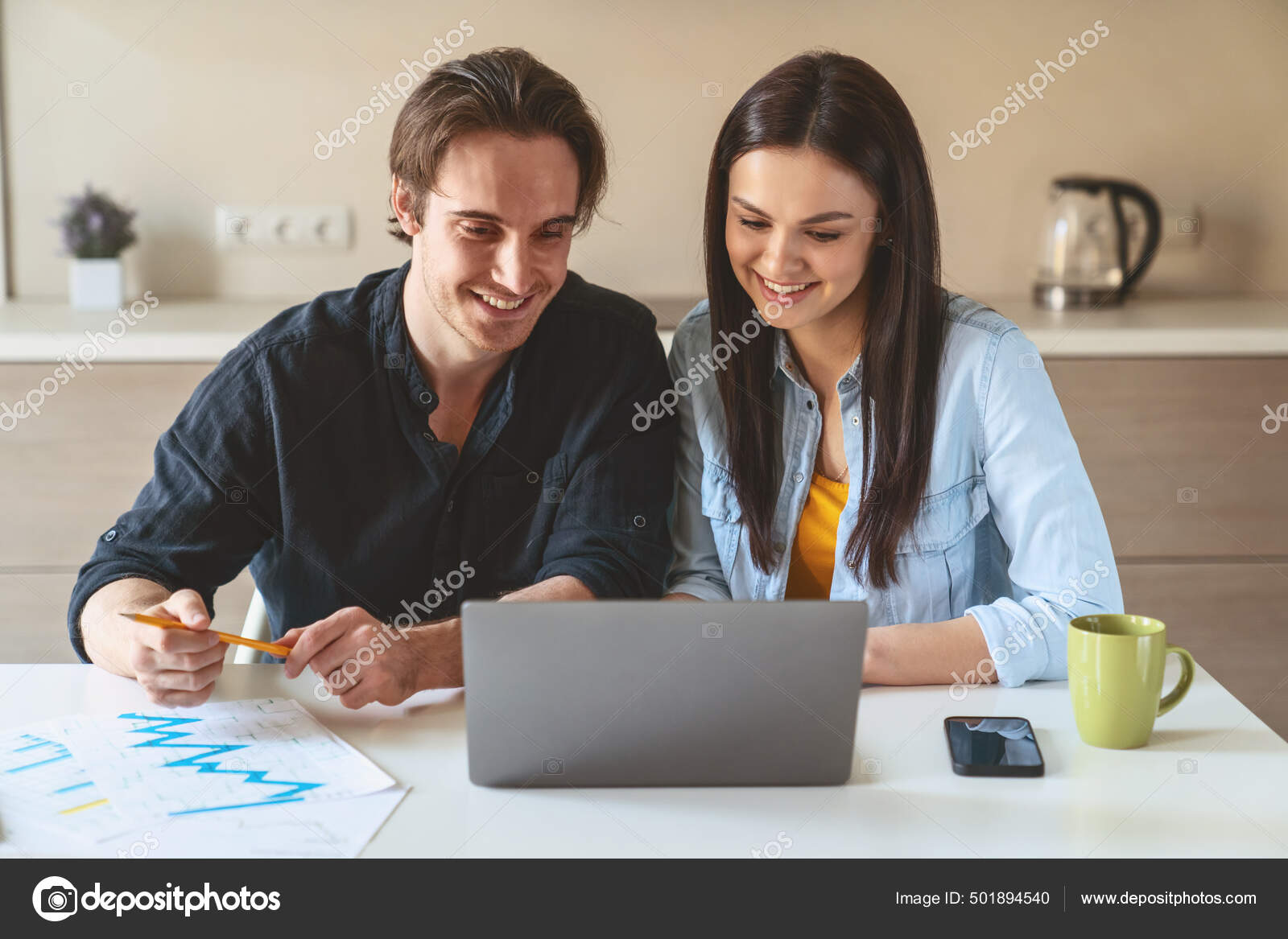 Young Married Couple While Working Home Sitting Table Kitchen Using ...