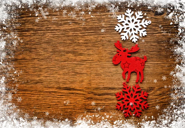 Christmas figurine elk and snowflakes on a wooden snowy background ...