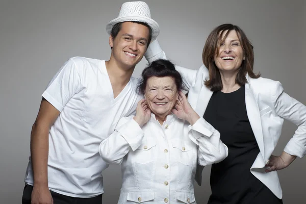 Happy three generations family posing on gray background. Stock Photo ...