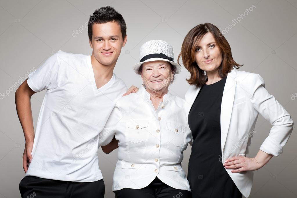 Happy three generations family posing on gray background. Stock Photo ...