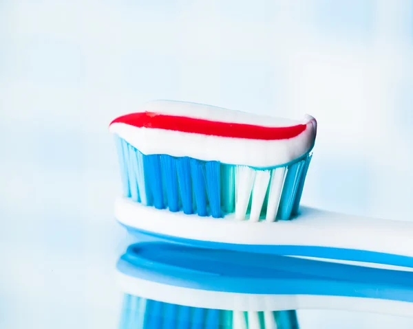 Toothbrush with red stripe toothpaste Stock Photo by ©nikkytok 123658464