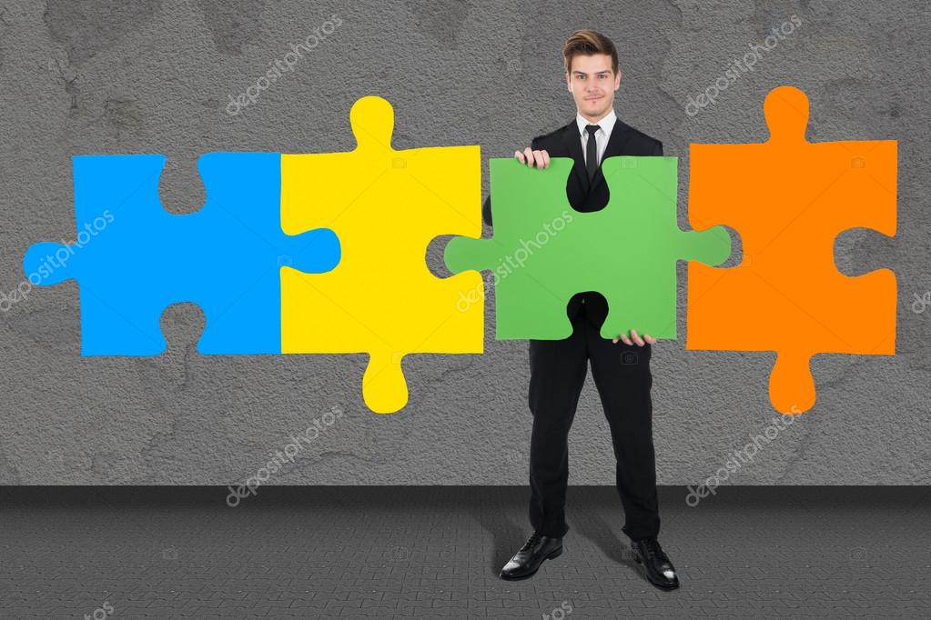 Confident Businessman Solving Jigsaw Puzzle Stock Photo by ©AndreyPopov ...