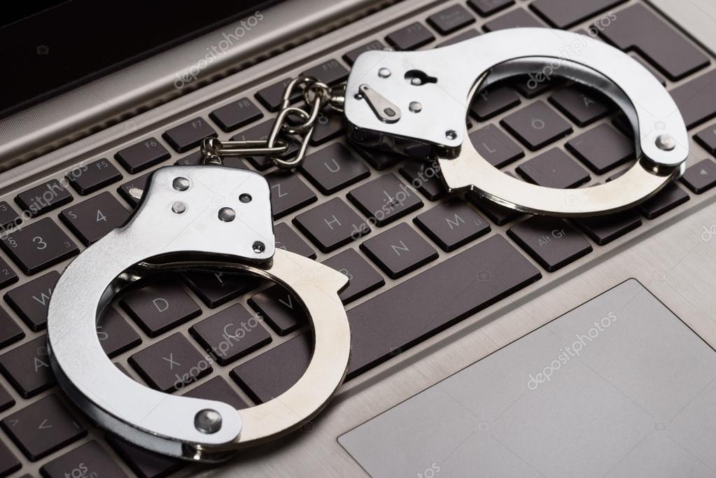 Handcuffs On Laptop Keypad Stock Photo by ©AndreyPopov 64646835