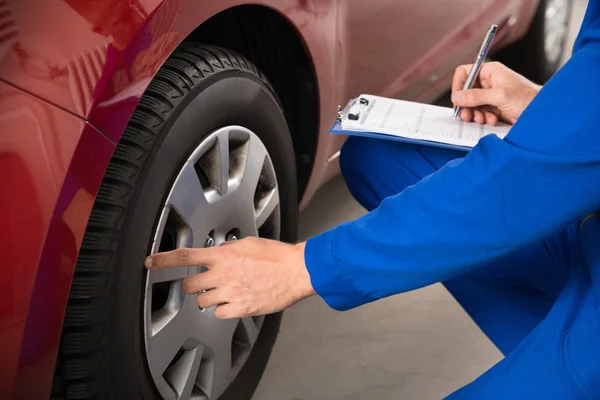 Mechanic Examining Car Wheel - Stock Image - Everypixel