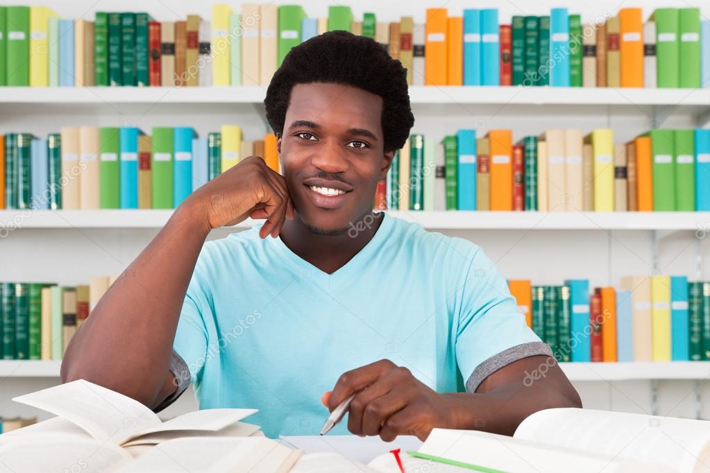 Happy Student Sitting In Library — Stock Photo © AndreyPopov #98721420