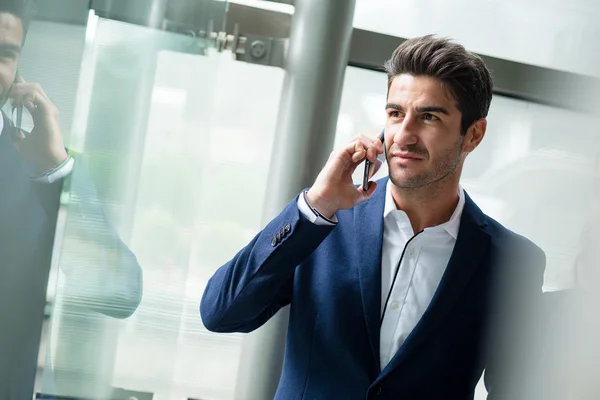 Businessman talking on smartphone inside office - Stock Image - Everypixel