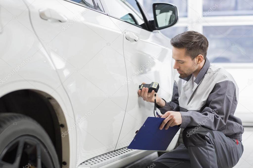 Repair worker examining car paint — Stock Photo © londondeposit #57282901