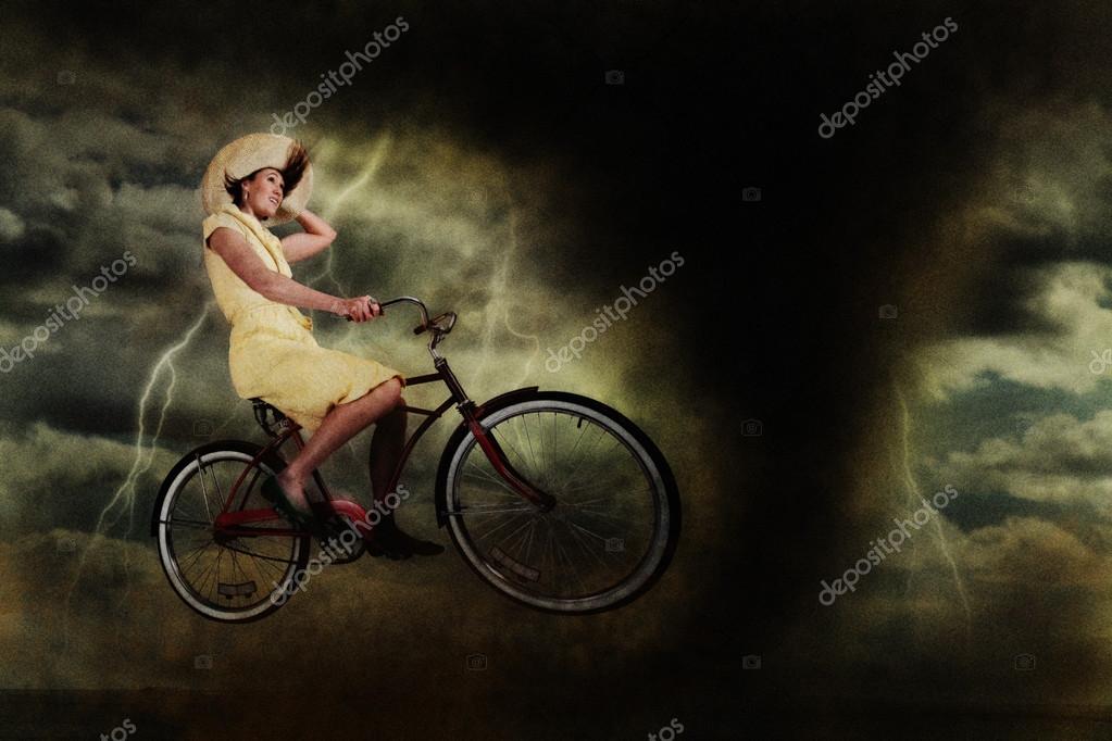 Girl on bicycle in tornado — Stock Photo © graphicphoto #53618009