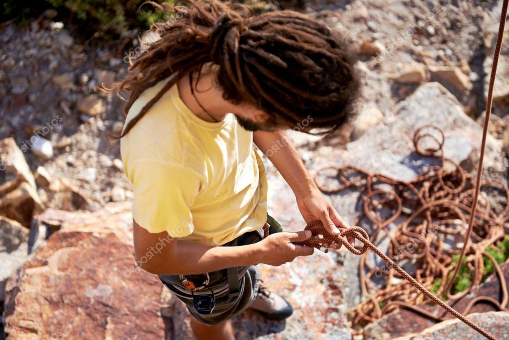 Man with dreadlocks tying ropes Stock Photo by ©Daxiao_Productions 74907369