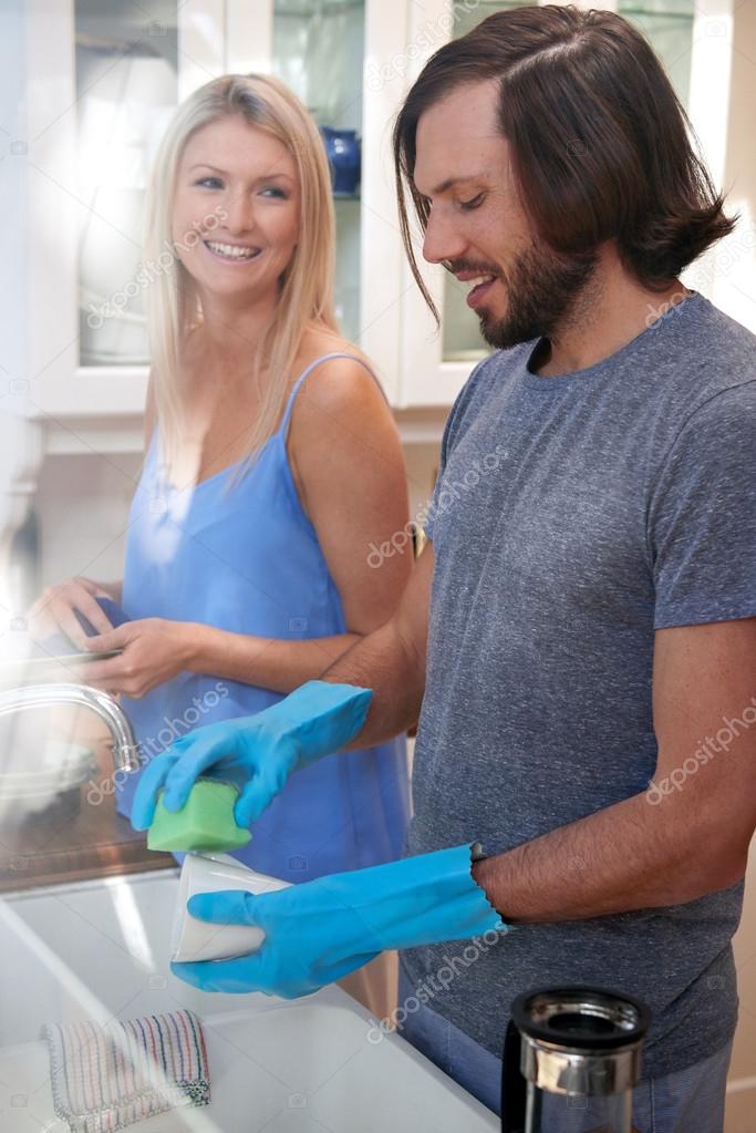 Couple doing household chores in the kitchen — Stock Photo © Daxiao ...