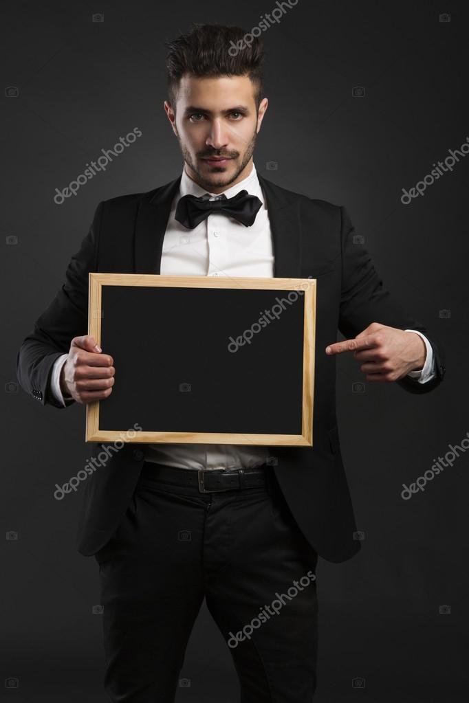 Young man holding a chalkboard Stock Photo by ©ikostudio 64048277