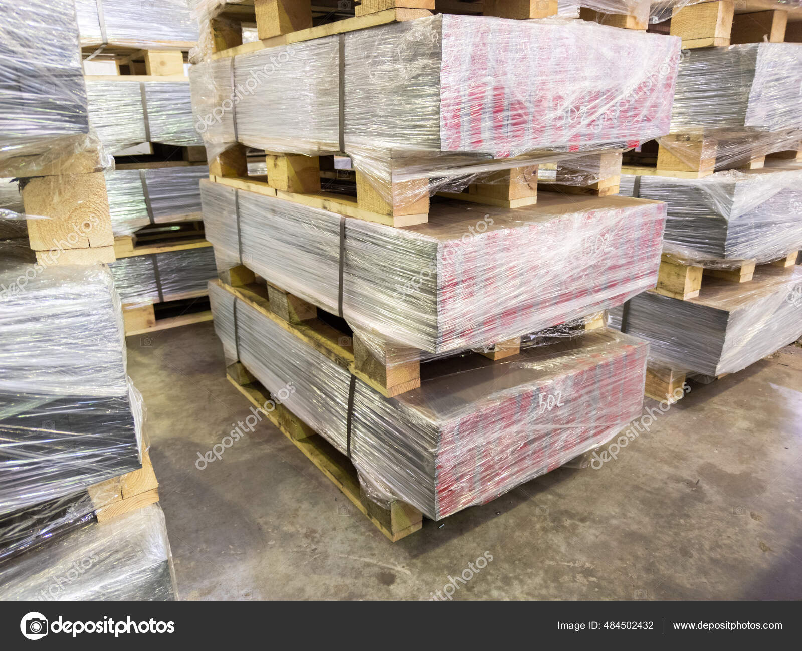 Abstract industrial palleted production stacks indoors on the floor ...