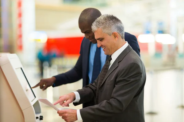 Travelers using check in machine - Stock Image - Everypixel