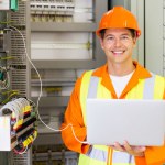 Engineer with laptop in machine control room Stock Photo by ...