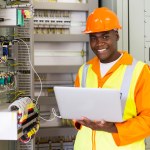 Engineer with laptop in machine control room Stock Photo by ...