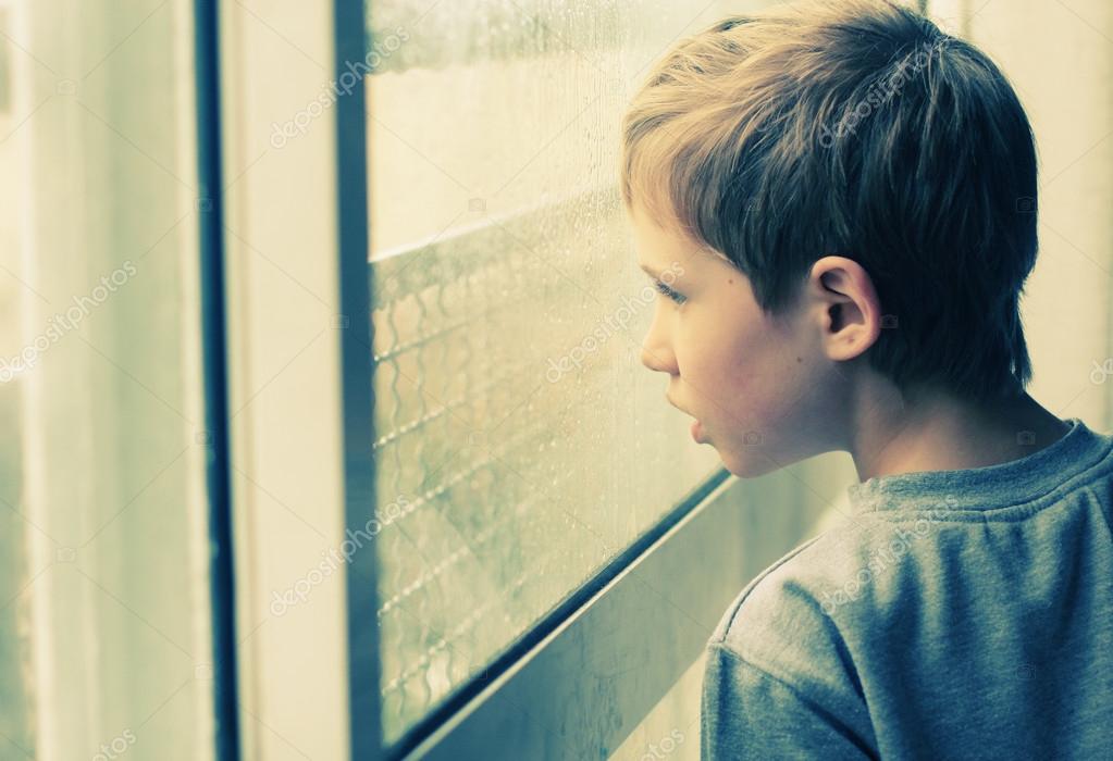 Little boy looking through window Stock Photo by ©Dubova 63972735