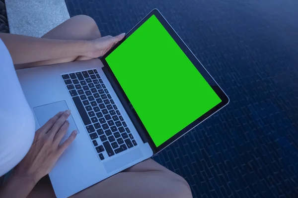 Hands closeup of woman in bikini with laptop computer on her knees ...
