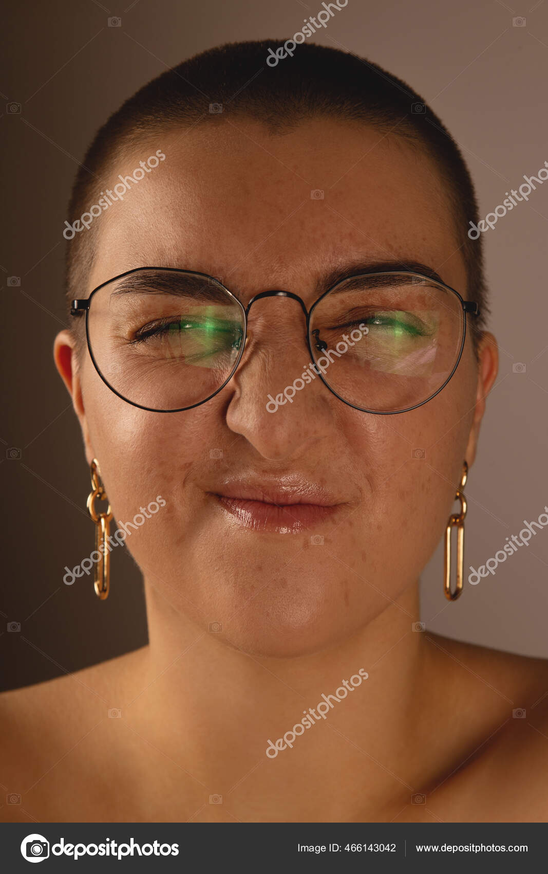 A swarthy girl with short hair and freckles in glasses grimaces and ...