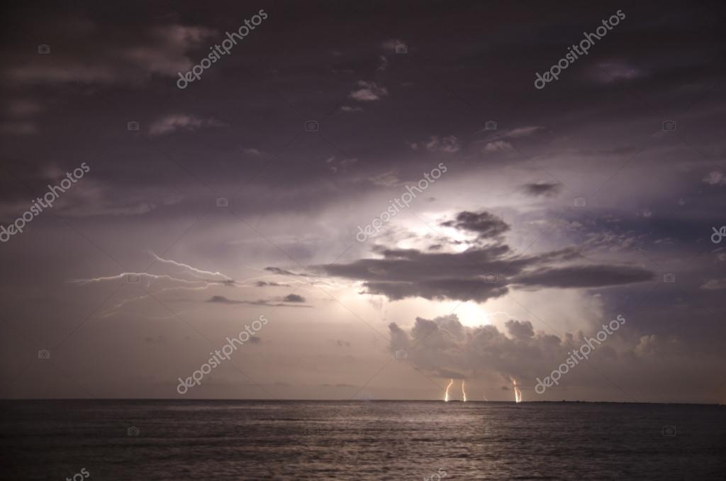 Tormenta y relámpagos en la noche sobre un mar con nubes dramáticas ...