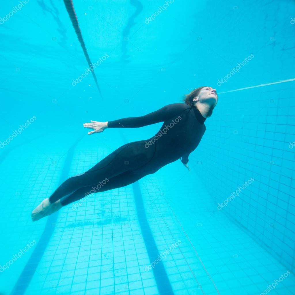 Female diver flying underwater in swimming pool Stock Photo by ...