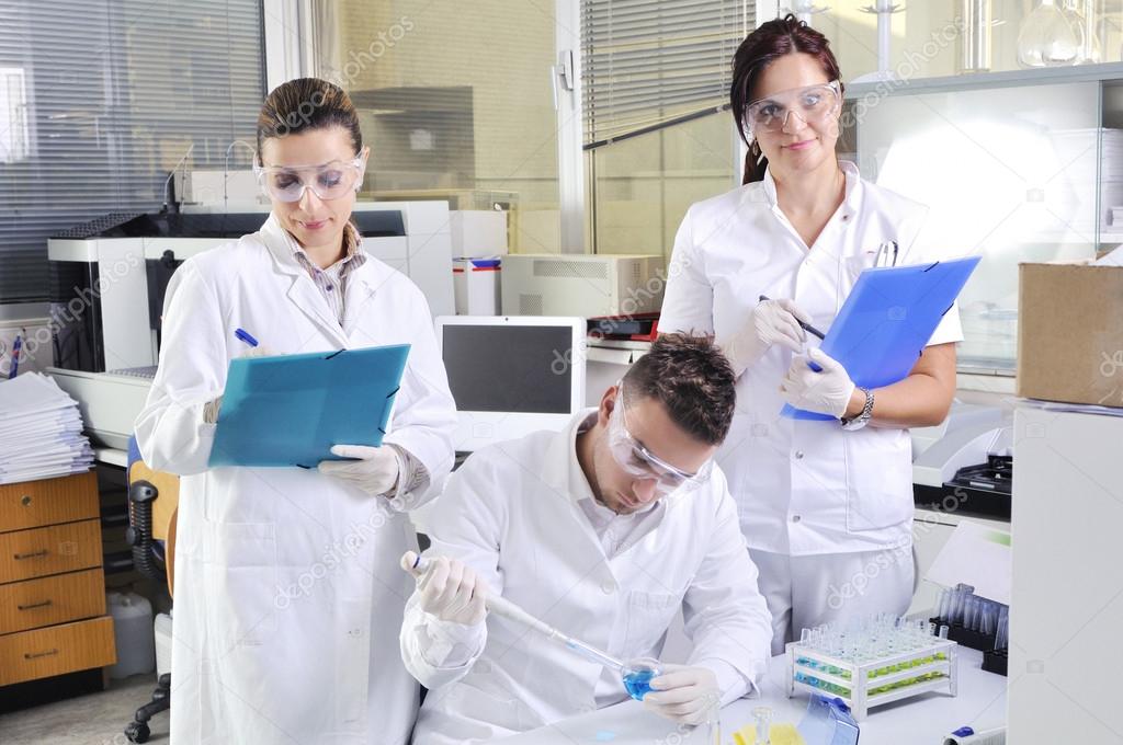 Attractive young PhD students scientists observing in the labora Stock ...