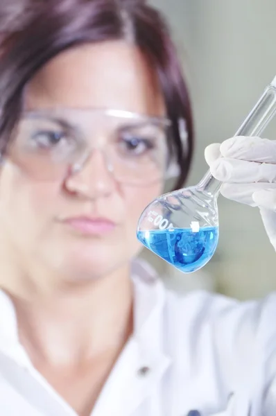 Attractive young PhD student scientist observing the blue indica Stock ...